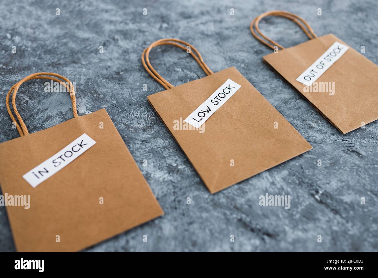 In stock, low stock and out of stock texts on top of shopping bags ...