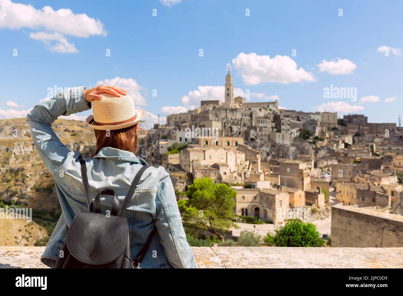 tourist girl with hat looking the stunning view of the Sassi di Matera ...
