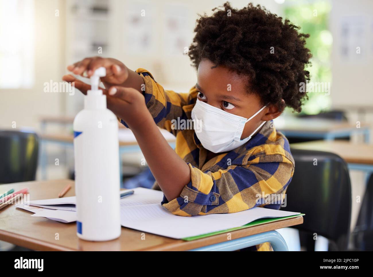 Student applying sanitizer in school class for hygiene, clean hands and ...