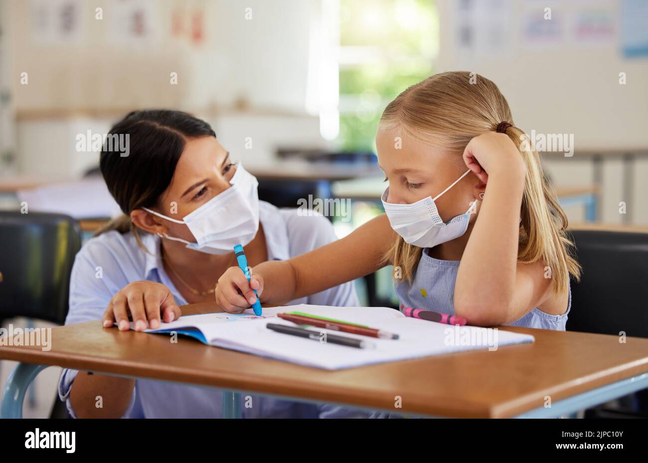 Education, covid and learning with face mask on girl doing school work ...