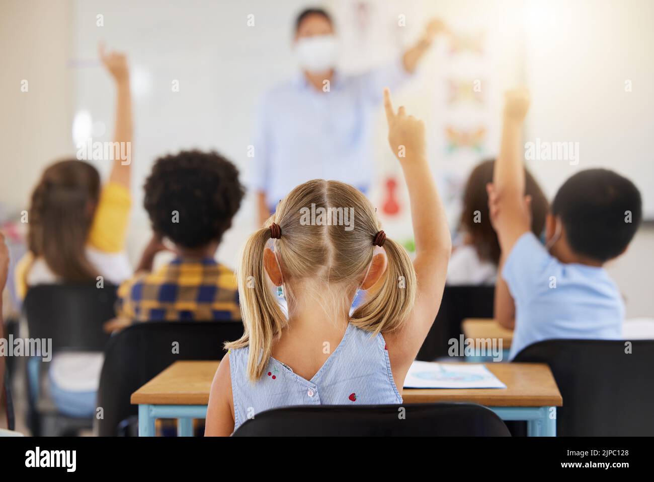 School students raising hands to volunteer, participate and answer ...