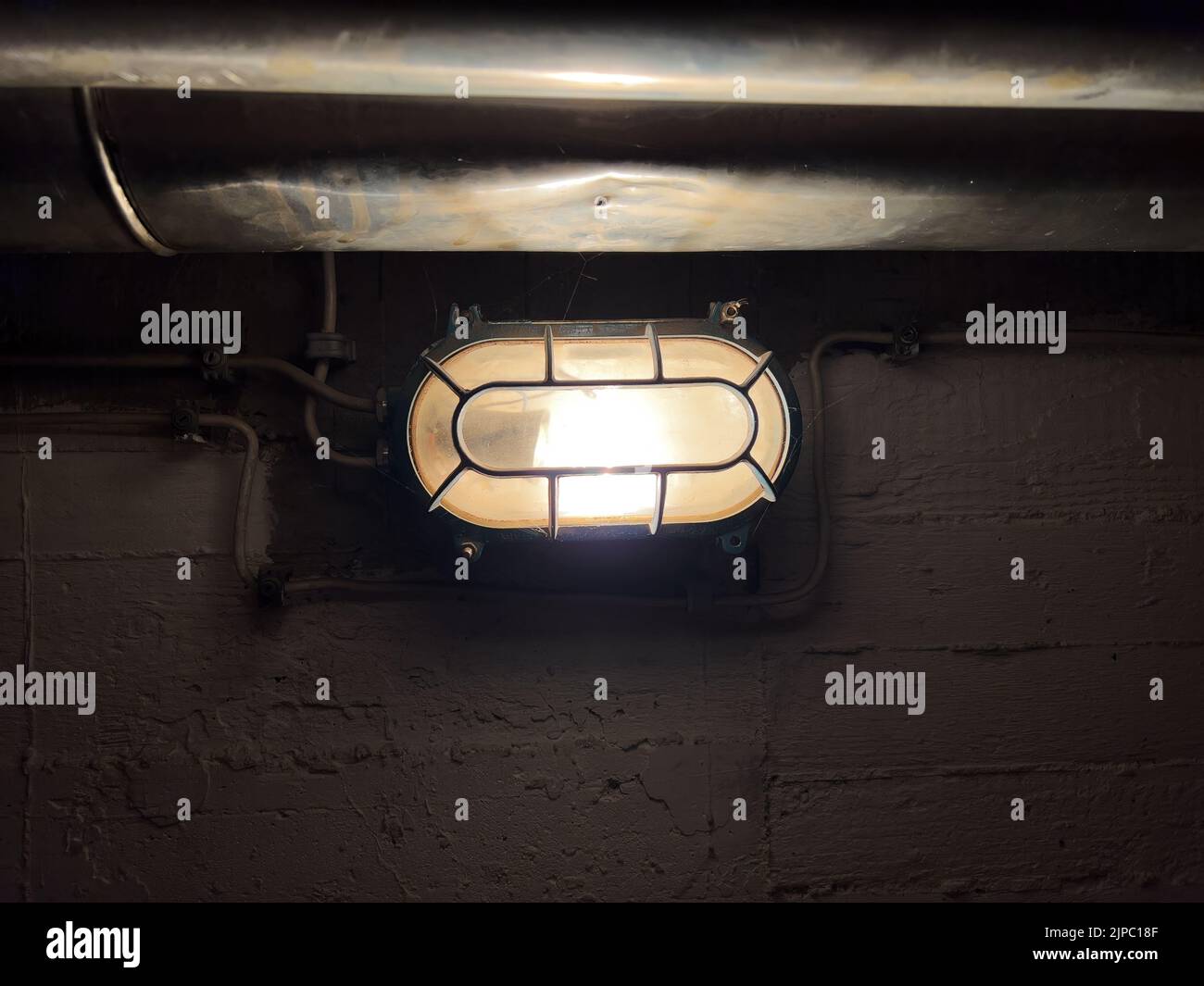 The close-up view of an old garage light illuminating the wall and the ...