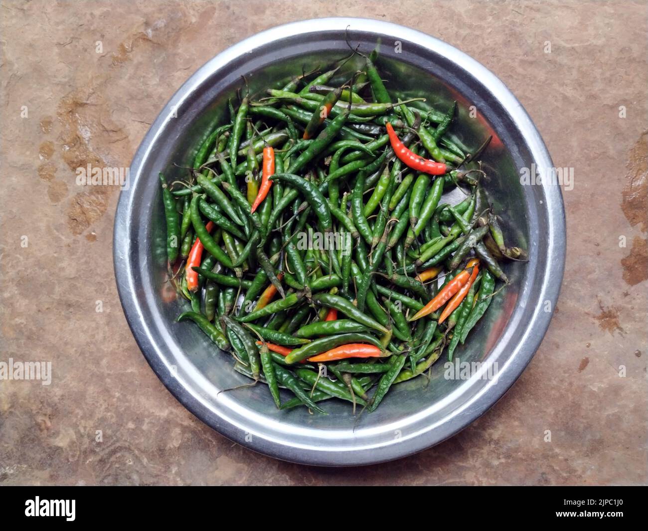 many green chillies and red chillies put in a big steel pot Stock Photo ...