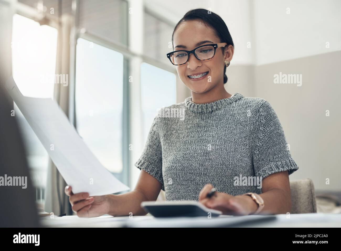 Home budget, finances and bills being calculated by a young woman ...