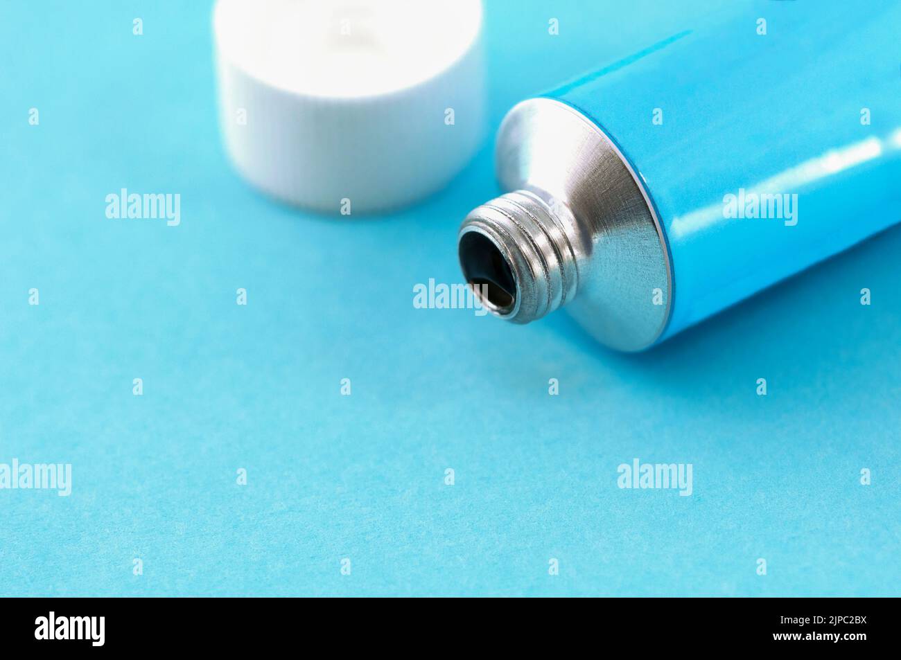 tube of ointment on a blue background close up Stock Photo - Alamy
