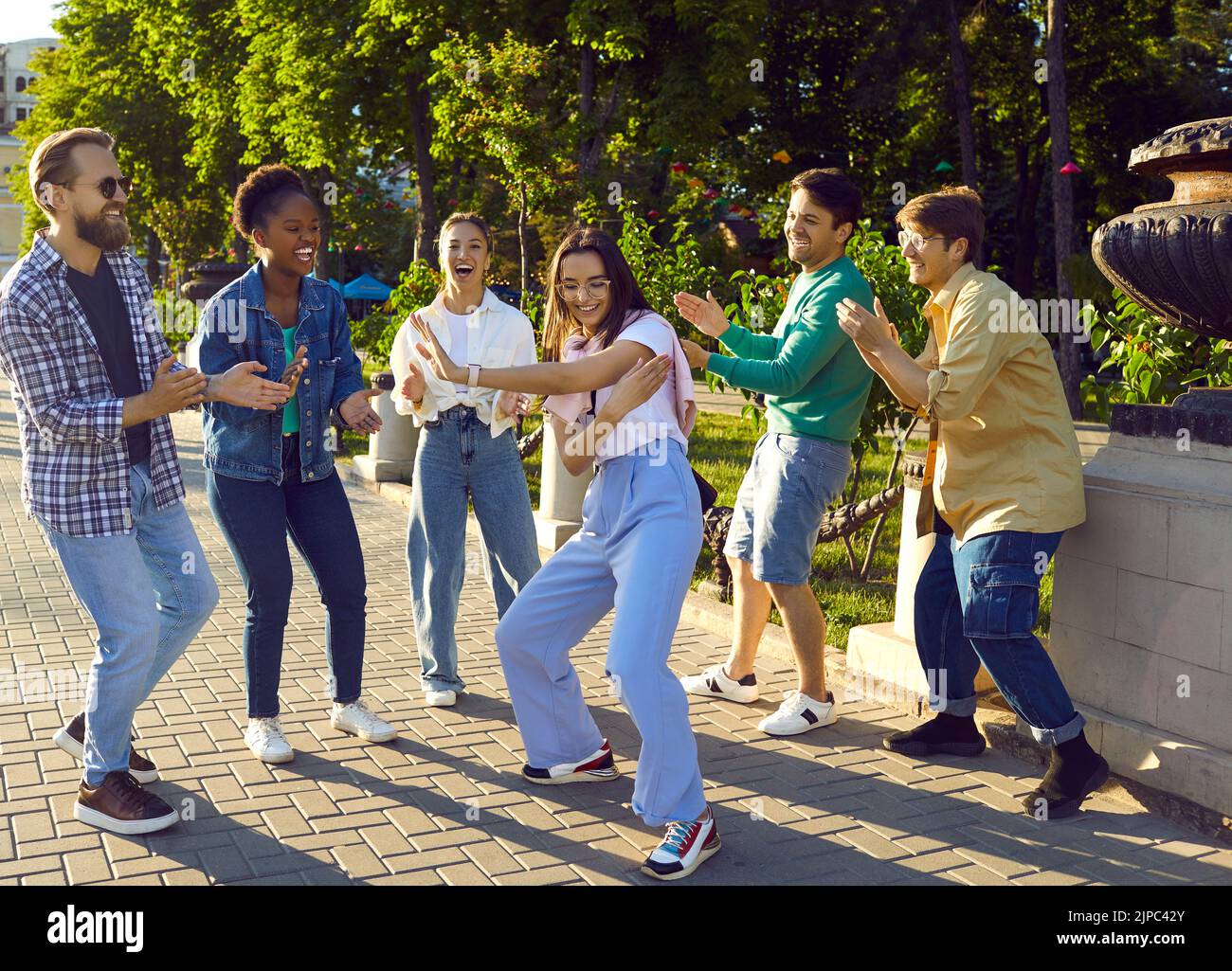 Happy young multiracial friends meet up, dance and have fun at the city ...