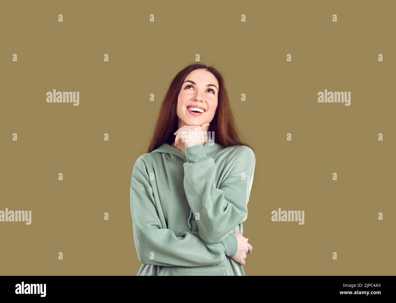 Smiling funny young woman who is thinking or imagining something nice ...