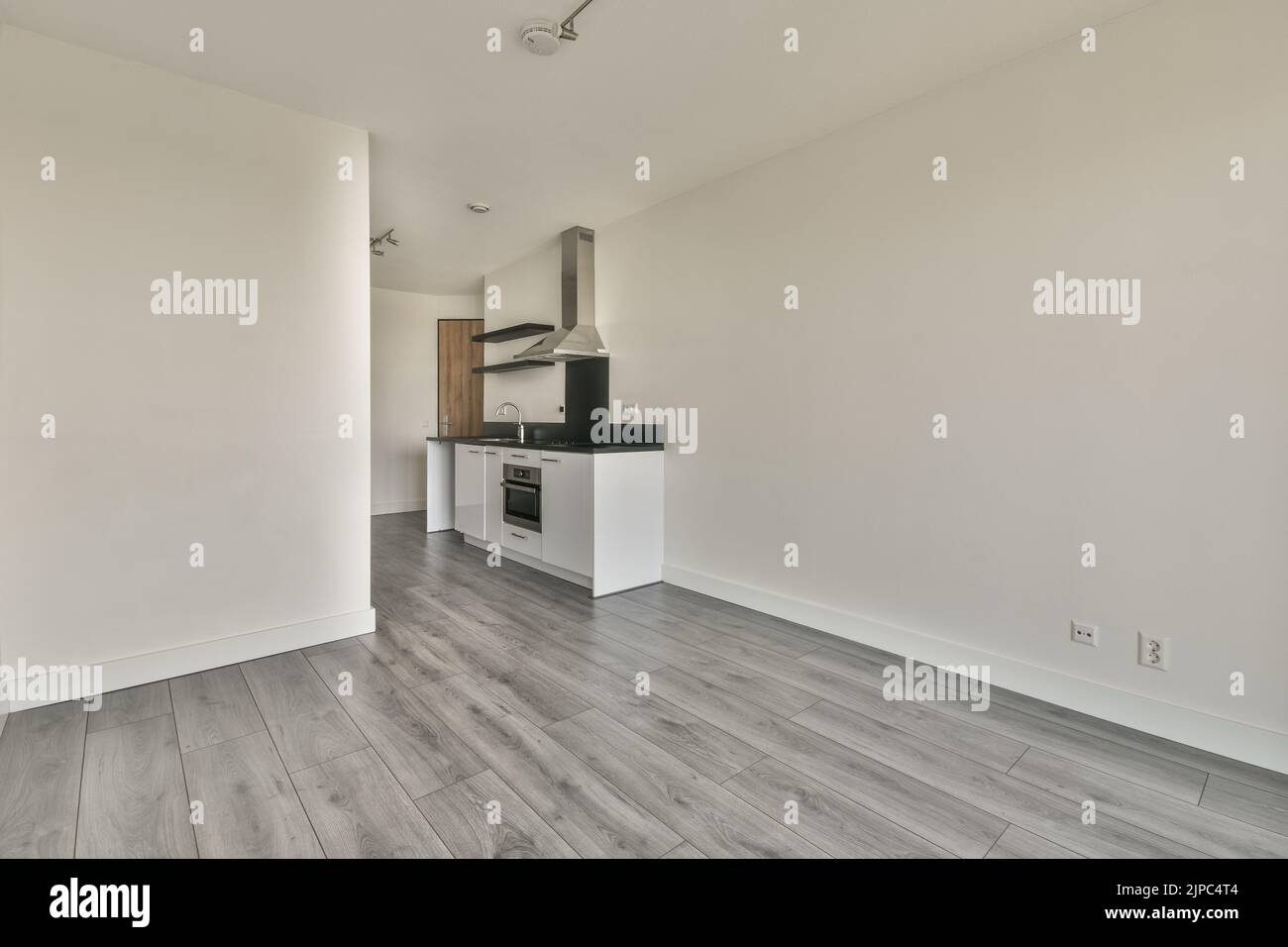 Interior of empty white kitchen with corridor and wooden parquet floor ...