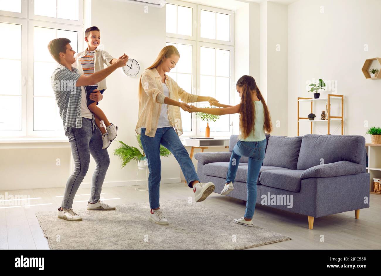 Happy mother, father and children playing games, dancing and having fun ...