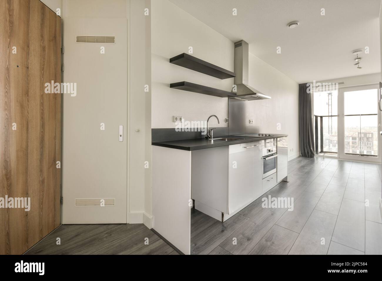Interior of empty white kitchen with corridor and wooden parquet floor ...