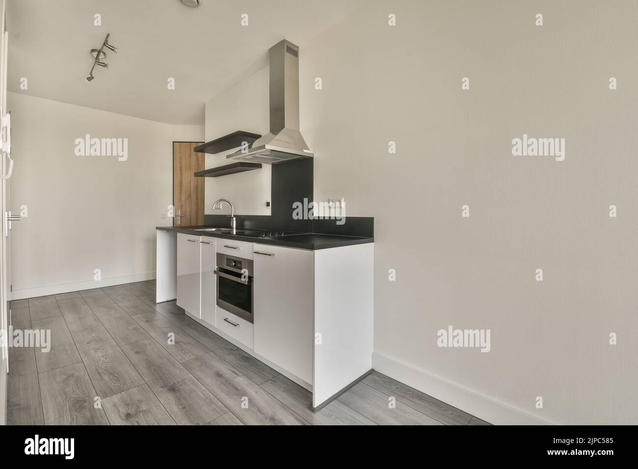 Interior of empty white kitchen with corridor and wooden parquet floor ...