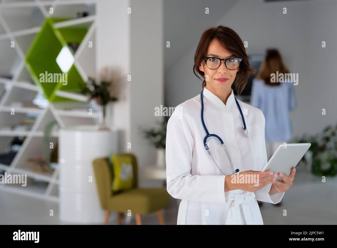 Portrait of a female doctor holding her patient chart on digital tablet ...