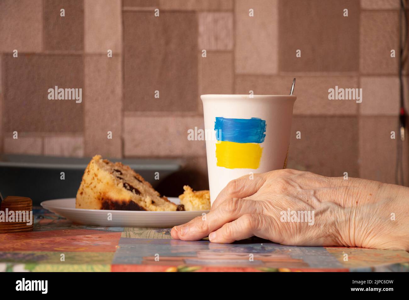 The yellow-blue flag of Ukraine is painted on a white cup with coffee ...