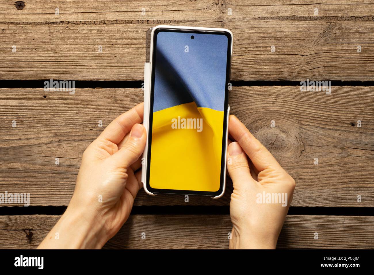 The national flag of Ukraine as a background on the phone in the hands ...