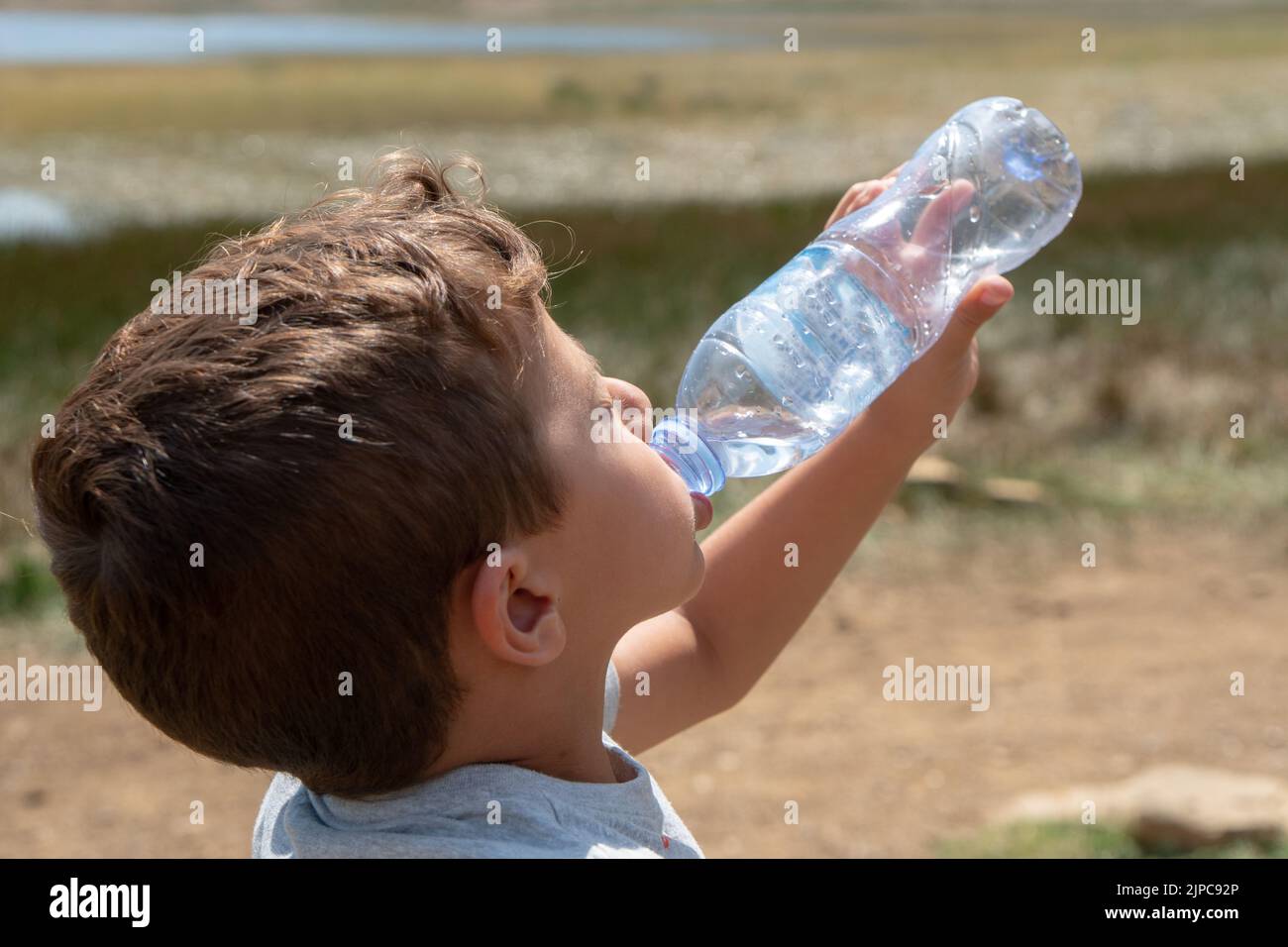 kid drinking water from a plastic bottle in the nature on a mountain landscape Stock Photo - Alamy