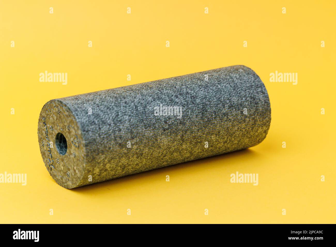 A Styrofoam roll to massage fascia and muscles isolated on yellow ...