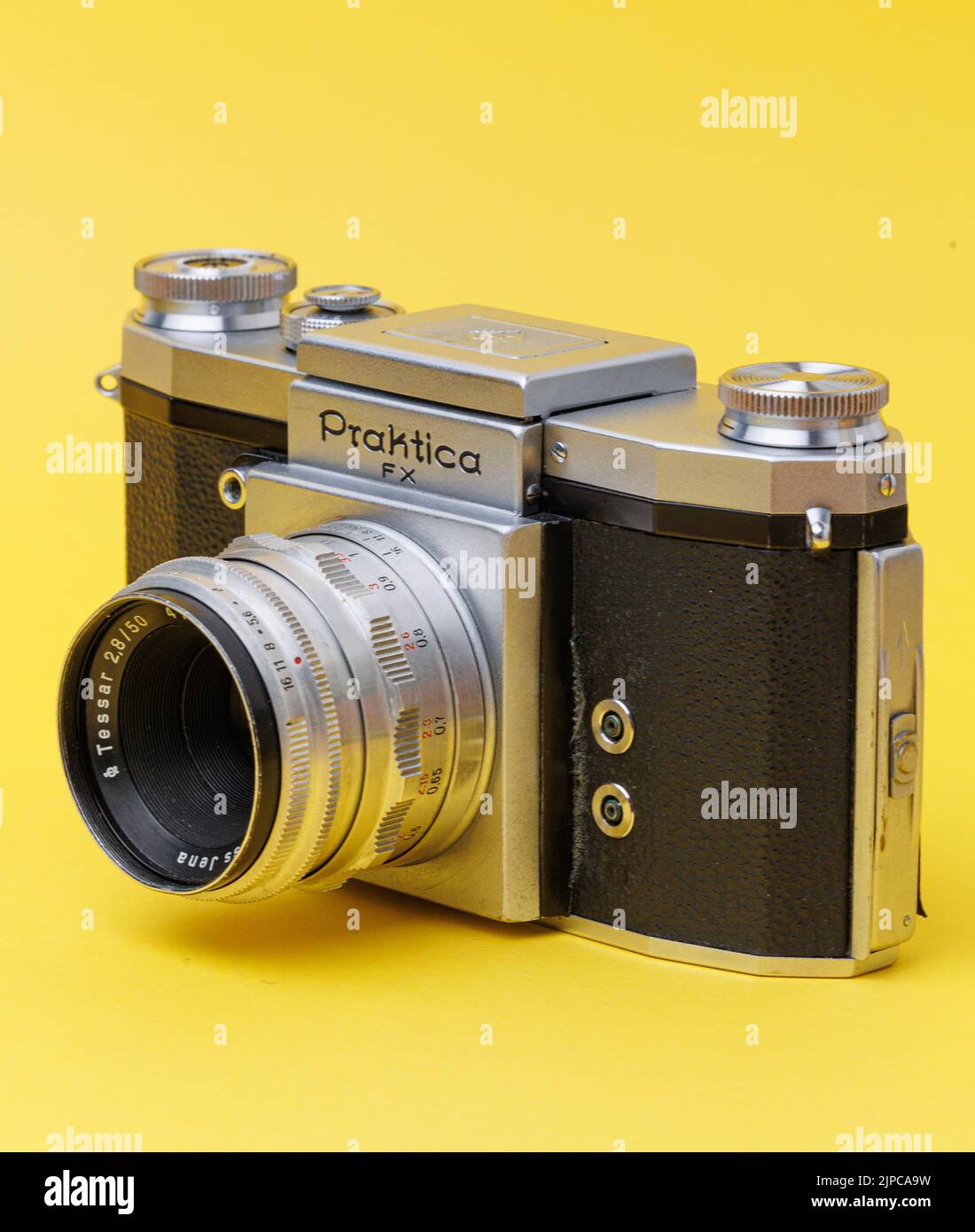 A close-up shot of an Old Praktica Film Camera isolated on the yellow ...