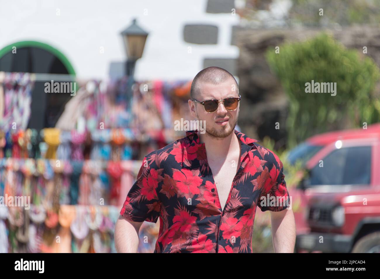 A shallow shot of a caucasian male wearing black glasses with sunlight ...