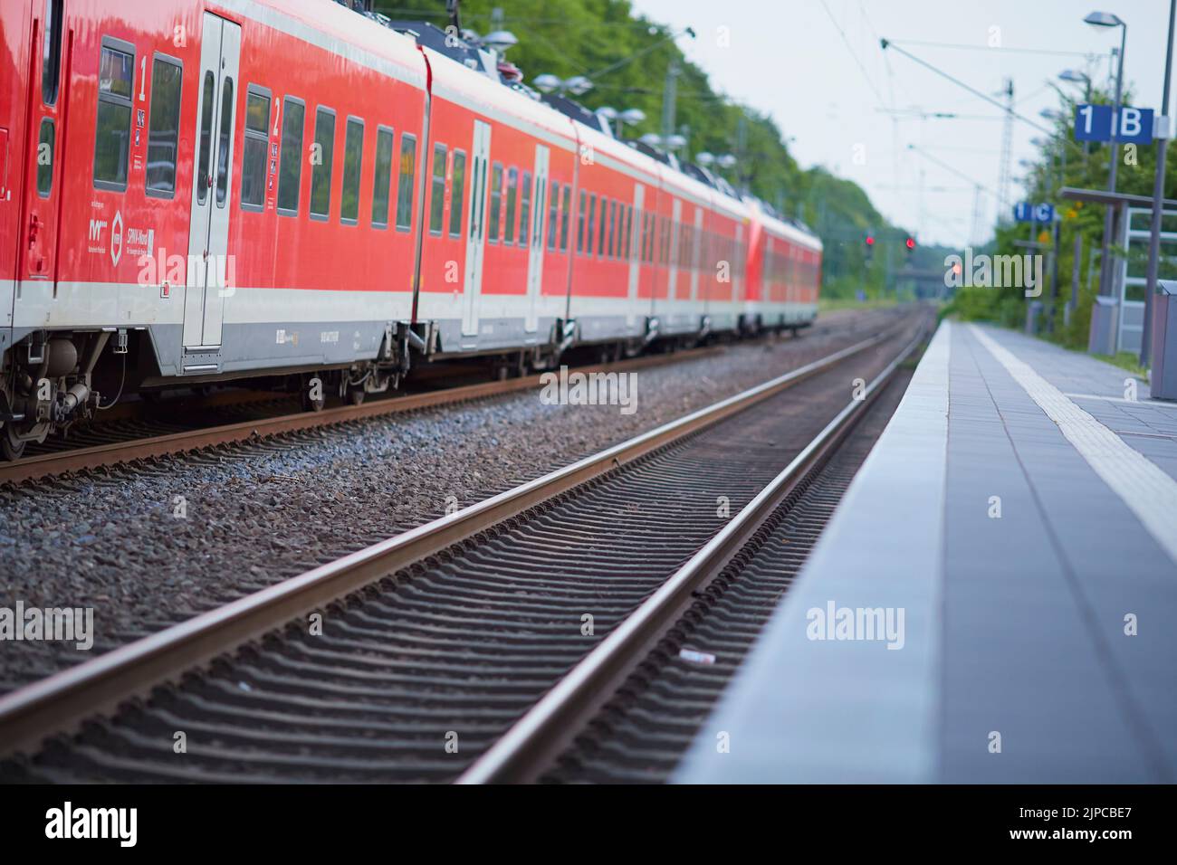 A red DB train arriving at a station in Geilenkirchen, Germany Stock ...