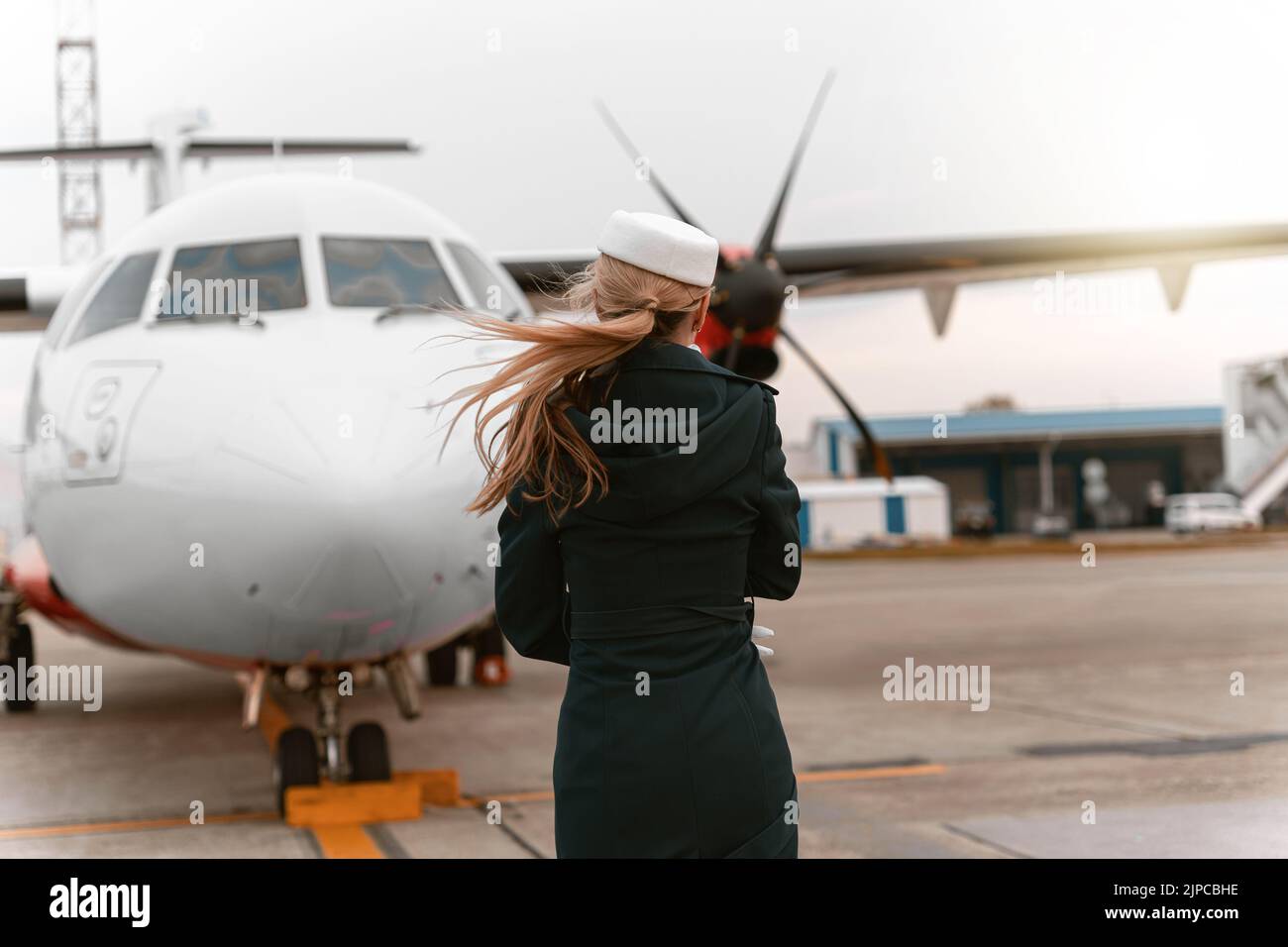 Back view of flight attendant looking on aircraft ready to flight Stock ...