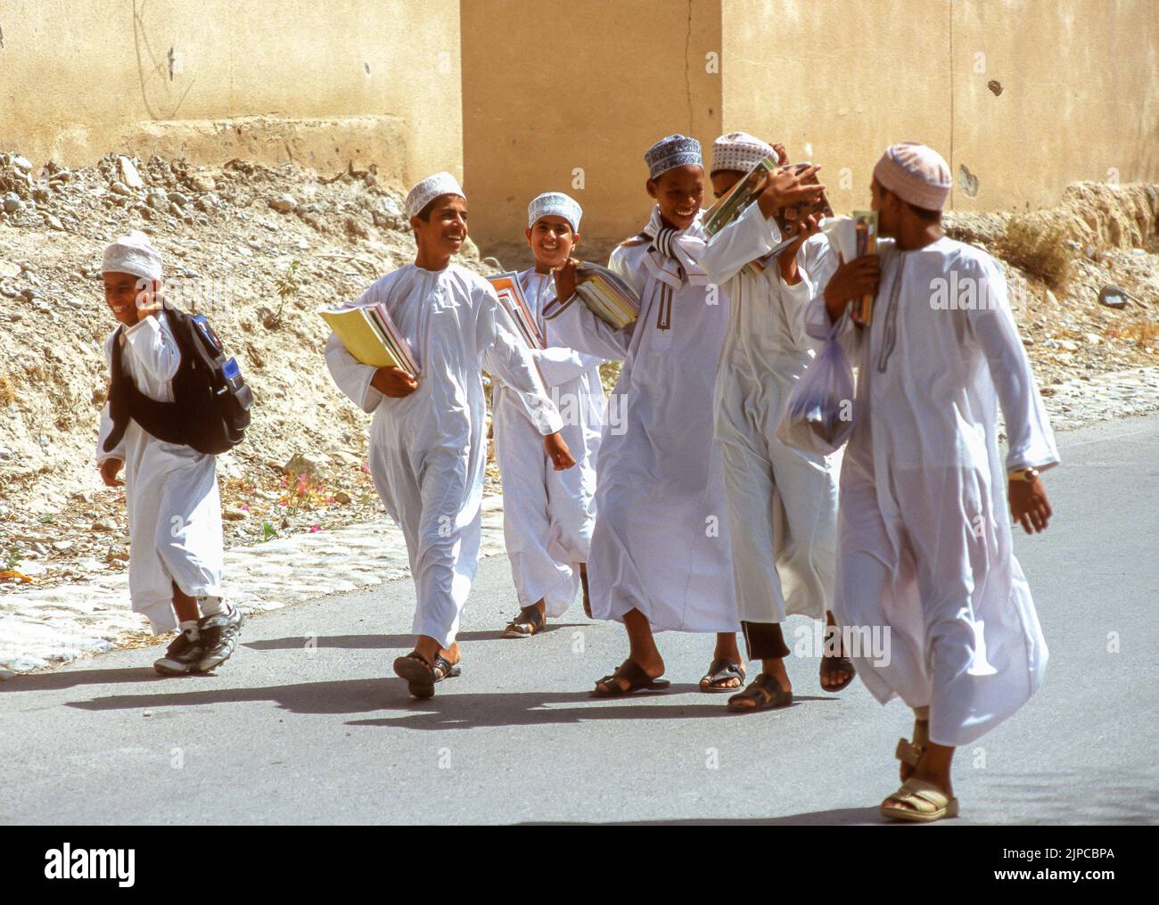 Schoolboys walking home in Rostaq, Sultanate of Oman. They wear the ...