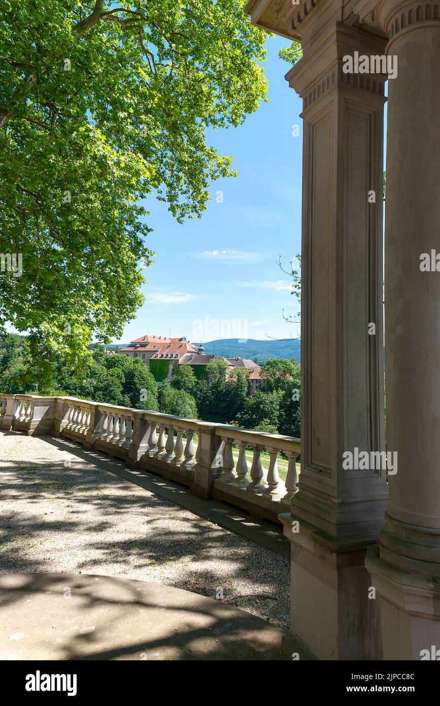 A vertical shot of a tree and concrete railings and pillars with a ...
