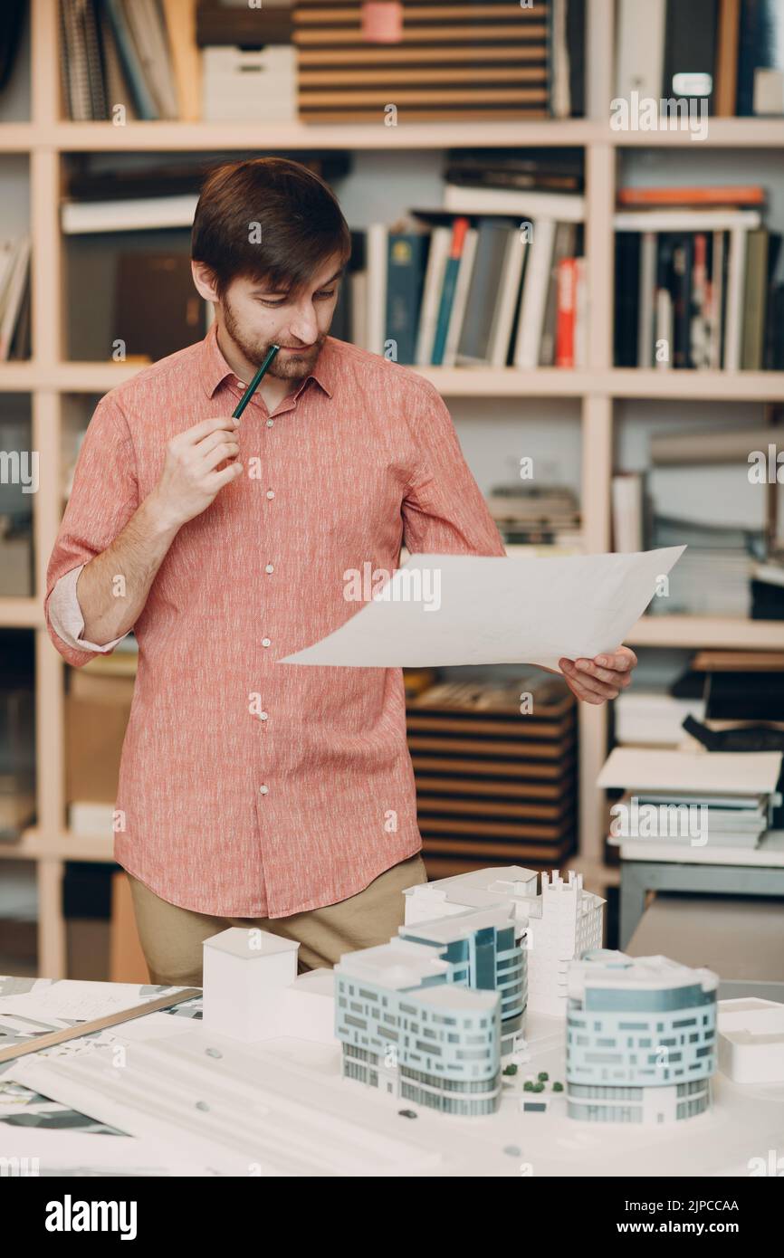 Architect with blueprints and layout design project at office bureau ...