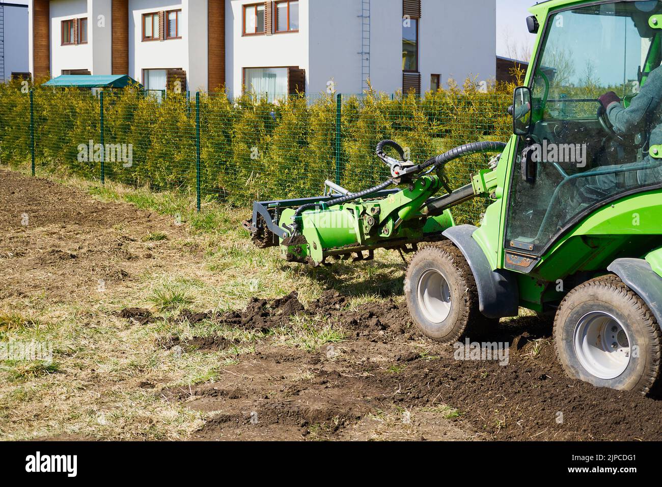 The tractor is cultivating the soil in the farm field. Freeing milling ...