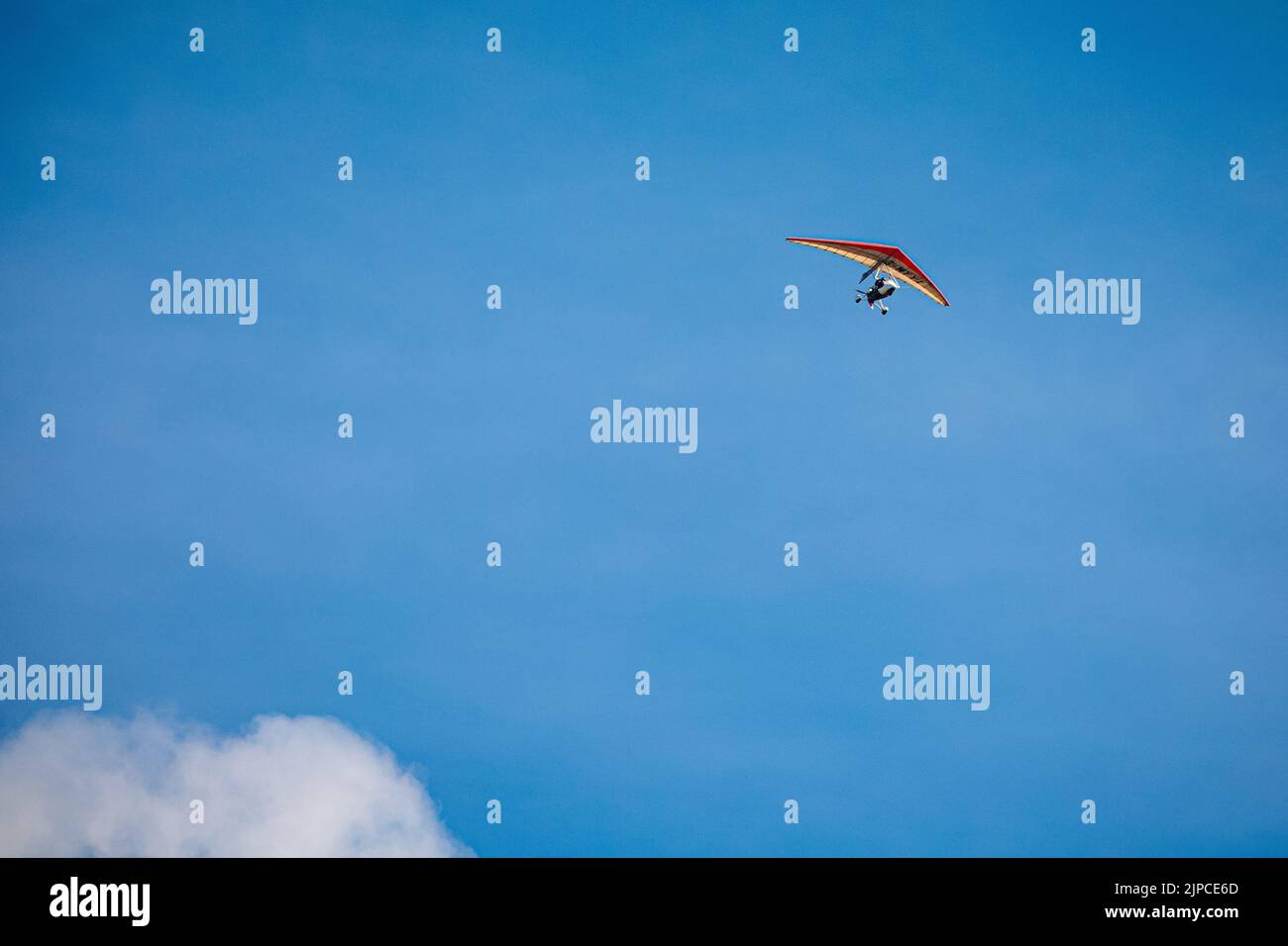 A view of hang glider flying high in the blue sky Stock Photo - Alamy