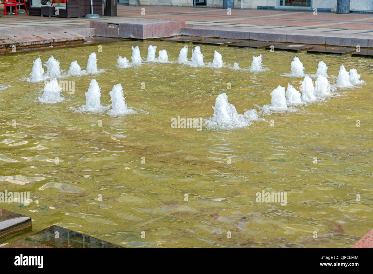 Small Water Jets in Green Fountain at City Square Stock Photo - Alamy