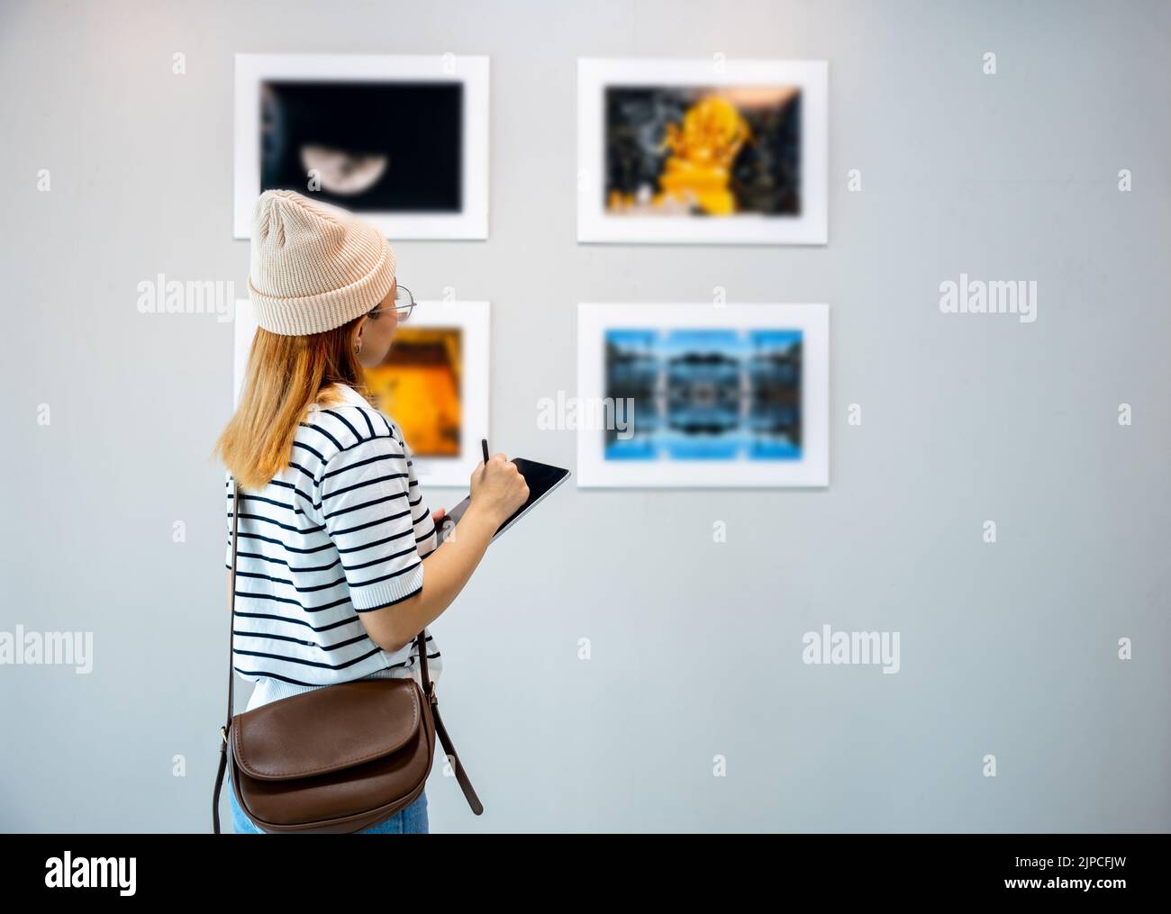 Young person at photo frame write digital book leaning against at show ...