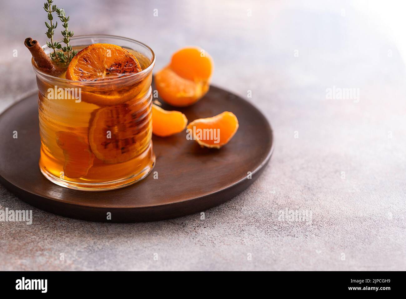 Whiskey sour cocktail with tangerine slices and ice cubes decorated ...