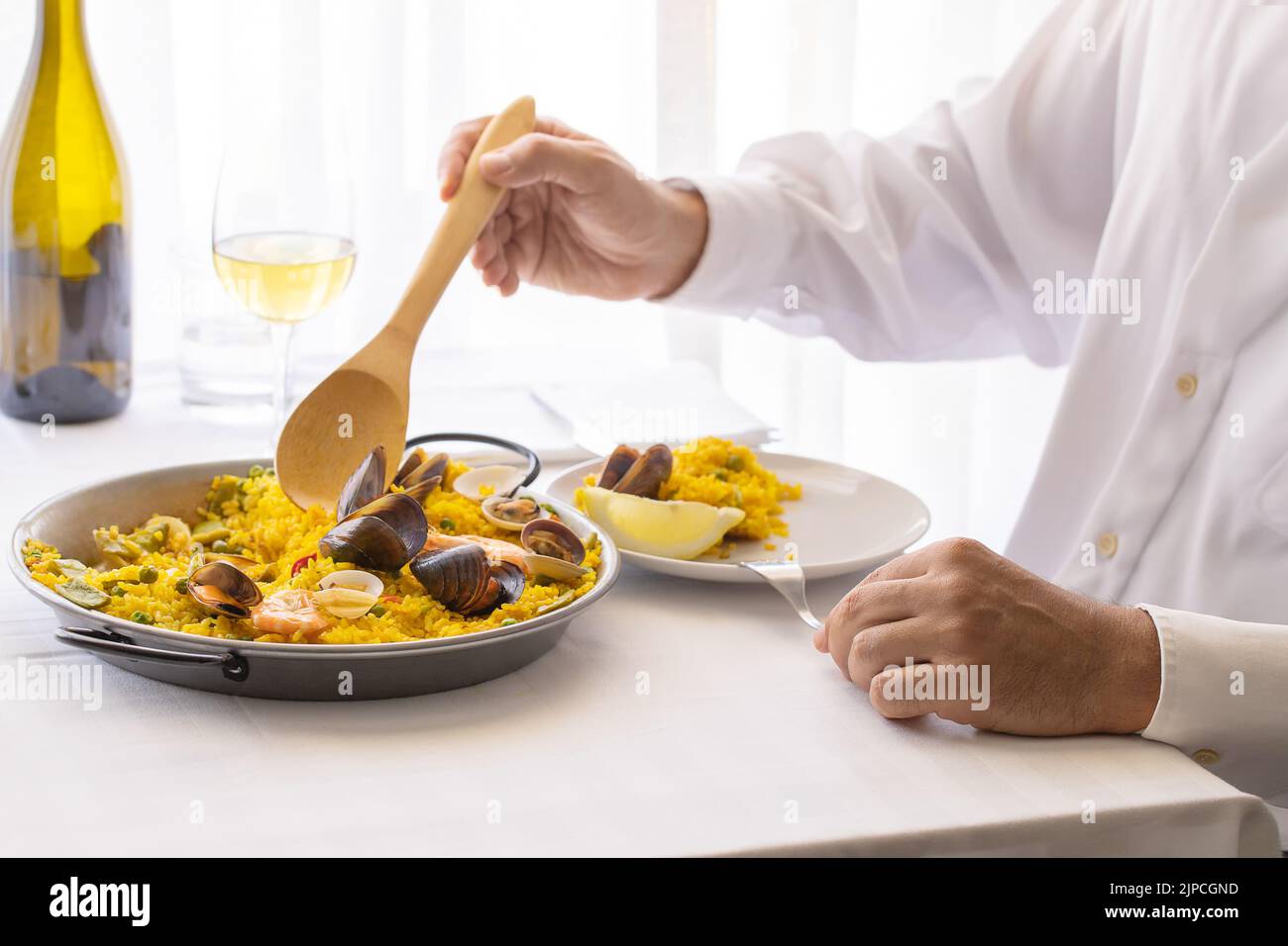 Man eating seafood paella in restaurant in Valencia, Spain. Typical ...