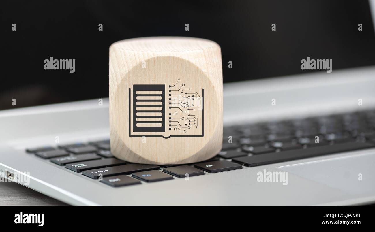 Wooden block with symbol of machine learning concept on laptop keyboard ...