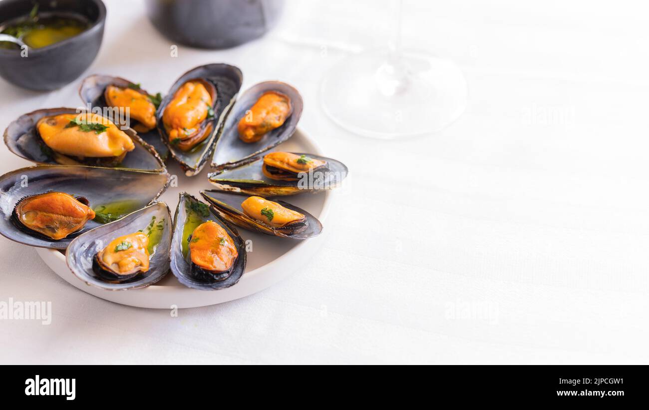 Steamed black mussels cooking in sauce and served with wine. Popular ...