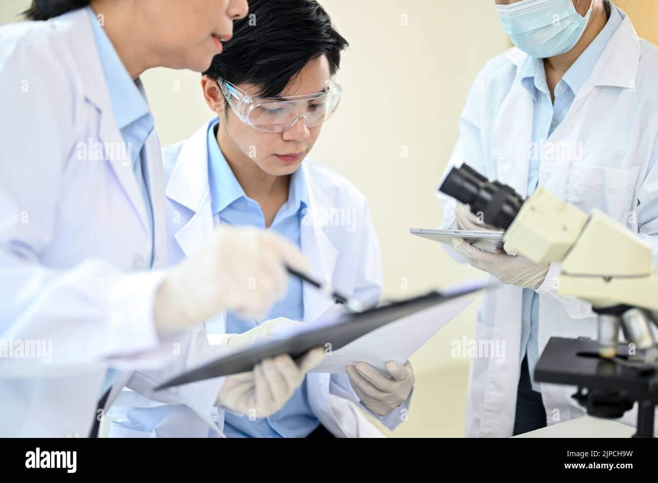 A team of Asian technician or scientist working together in the lab ...