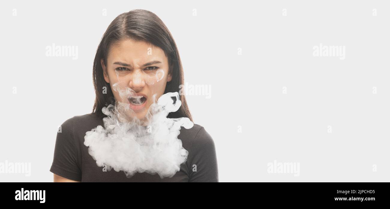 Angry young girl with dark hair releases smoke from the mouth isolated ...