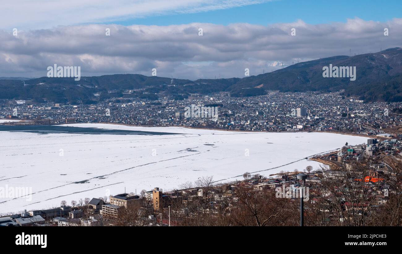 An overview of frozen Lake Suwa and Suwa City in winter in Nagano ...