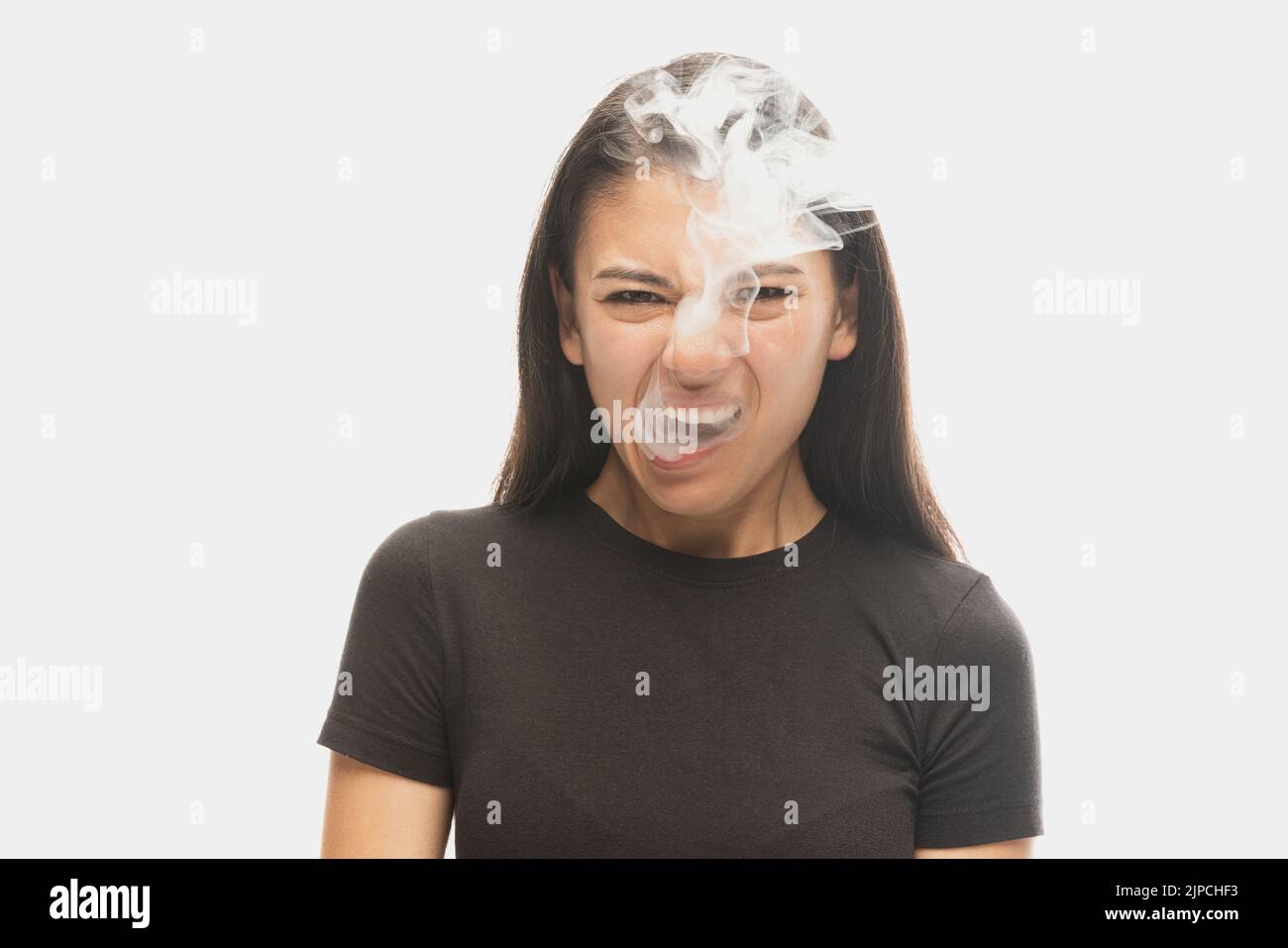 Angry young girl with dark hair releases smoke from the mouth isolated ...