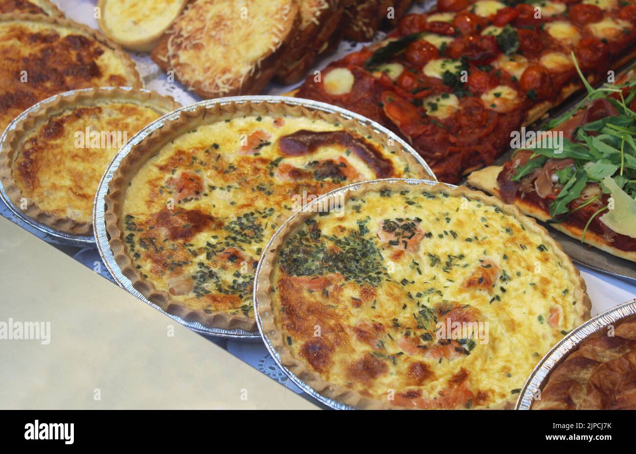 French Quiche lorraine on a window display in a row Stock Photo - Alamy