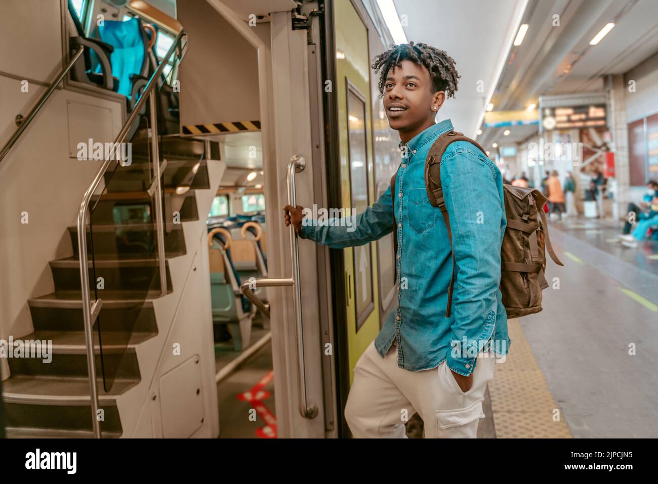 Guy holding handrail entering train car Stock Photo - Alamy
