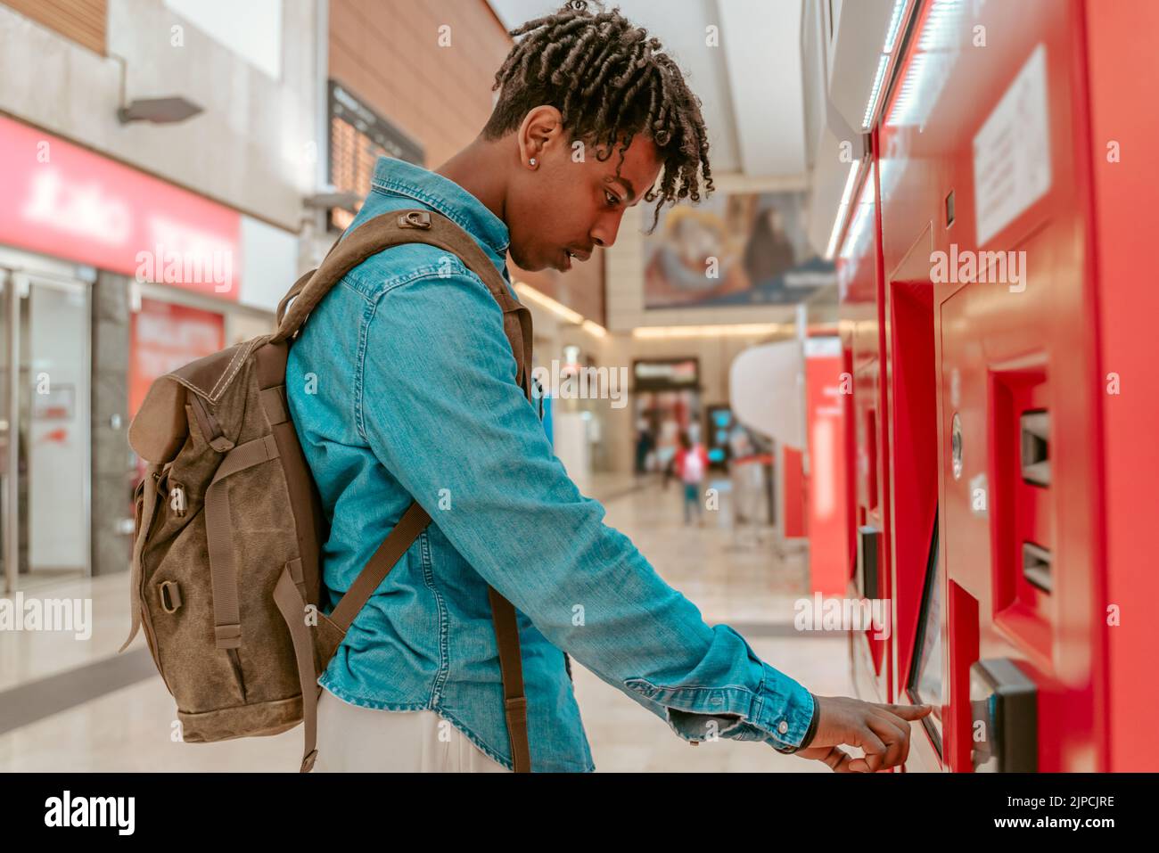 Guy standing sideways to camera near self-service terminal Stock Photo ...