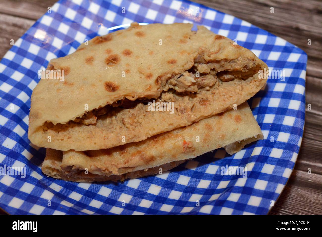 A flat bread with mashed fava beans mixed with oil, sesame tahini ...