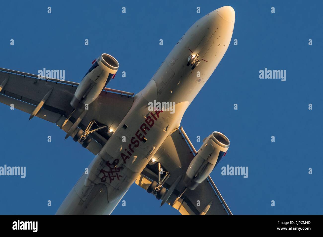 Air Serbia Airbus A319 in flight close up seen directly from bellow ...