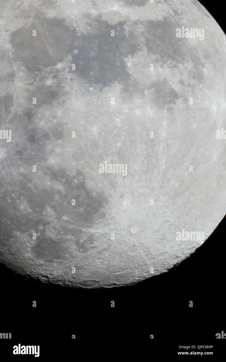 A vertical closeup shot of the moon surface with craters after hitting ...