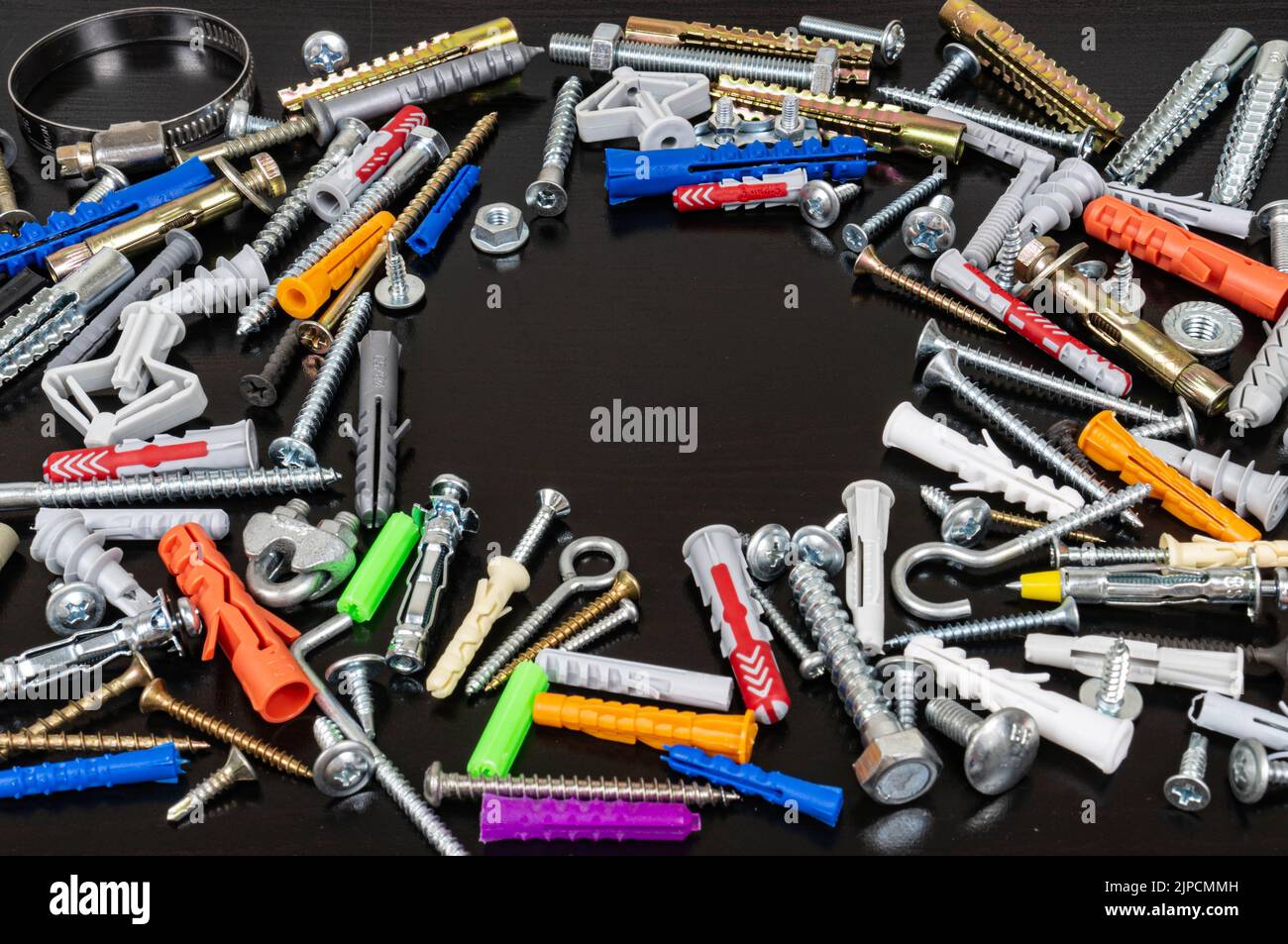 Different types of fasteners on a dark wood background. Front view ...