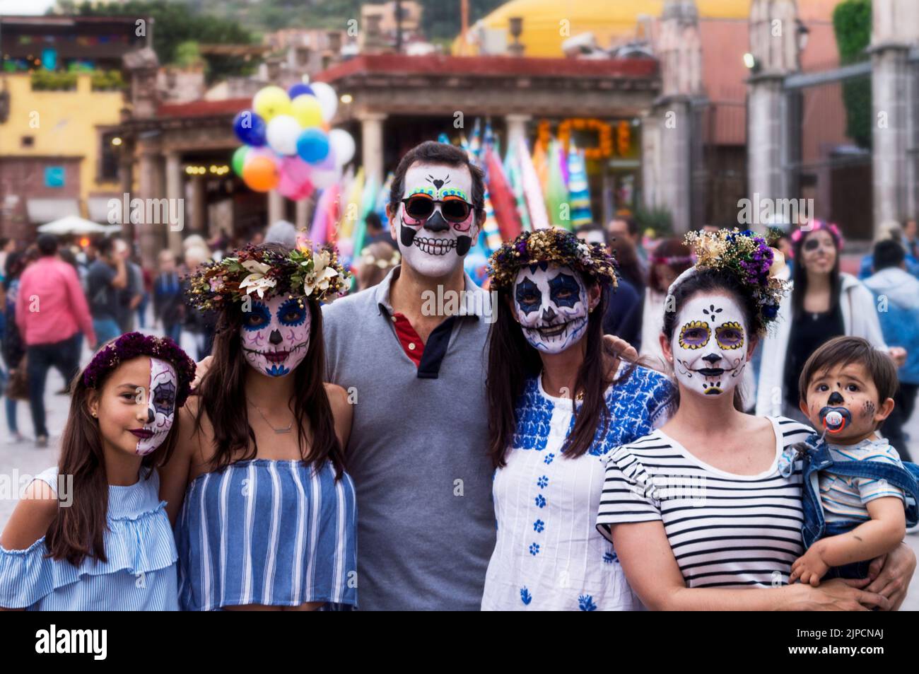 A beautiful shot of a family wearing skull makeup celebrating the day ...