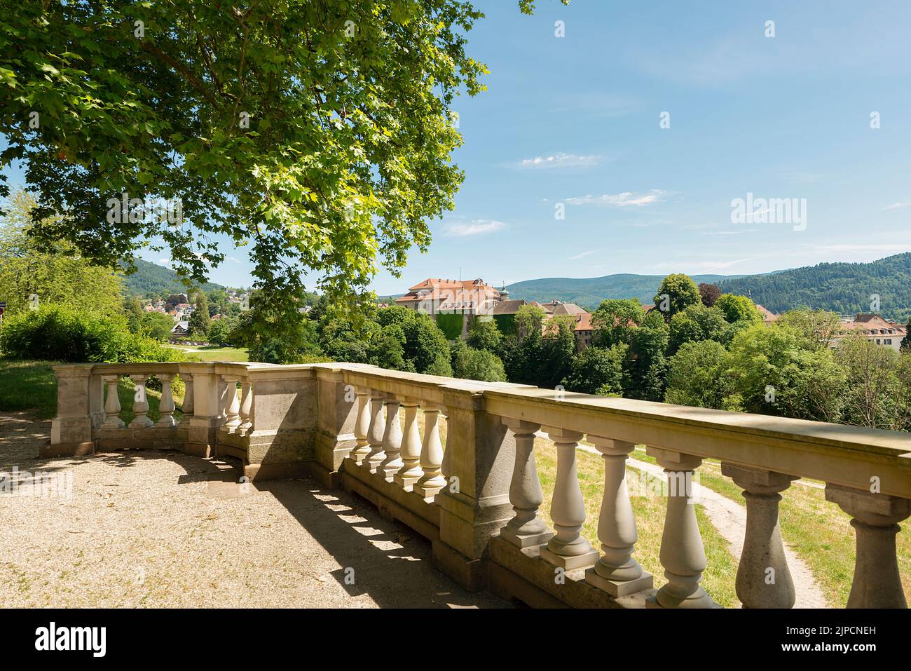 The stone balusters in the park with lush green trees under blue sky ...
