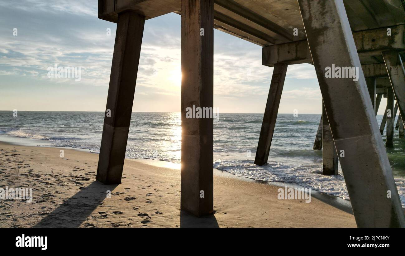 The sunrise at the beach under a pier Stock Photo - Alamy