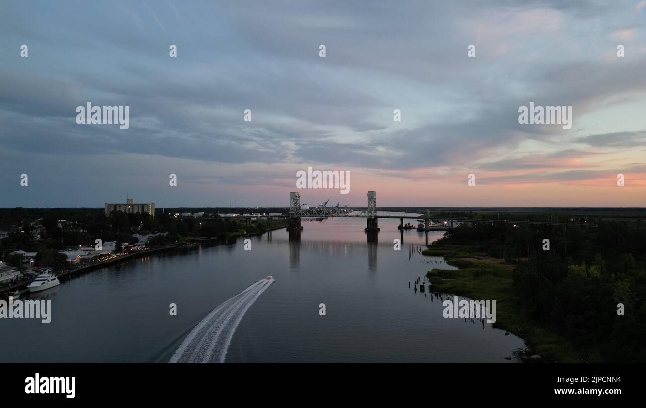 A boat sailing down the river towards a bridge Stock Photo - Alamy
